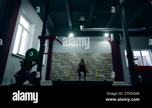Medium shot slow mo tilt-down tilt-up men exercising and lifting ...
