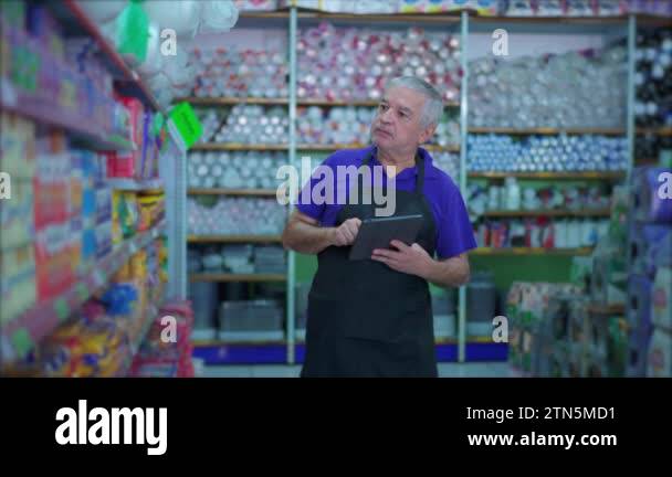Senior manager of grocery store checking inventory of products on shelf ...
