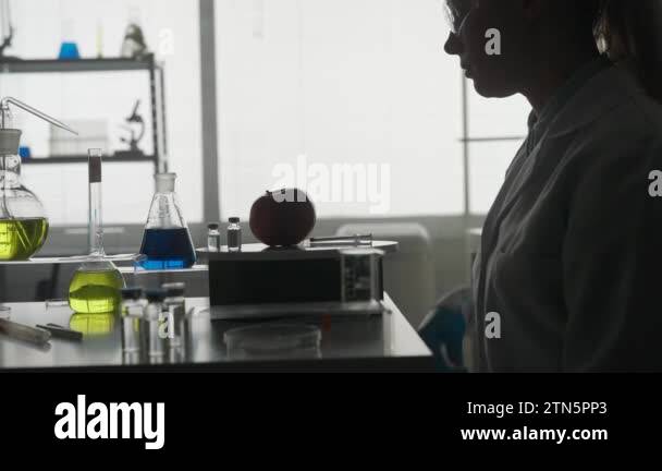 Dark silhouette of a female scientist with a syringe in her hand in a ...