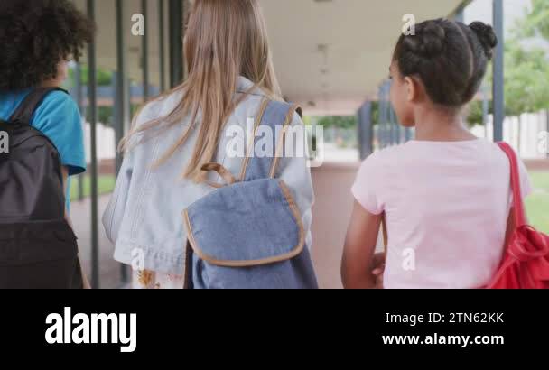 Video of rear view of three diverse schoolgirls walking in school ...