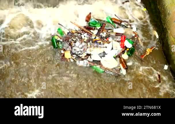 Slow motion. Plastic bottles and another mess turning on water level ...