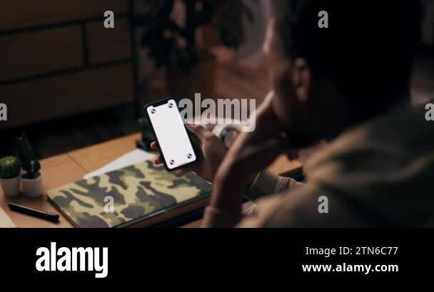 Freelancer man in the photo, holding a cellphone and laptop with white screens, is Marcus, a ...