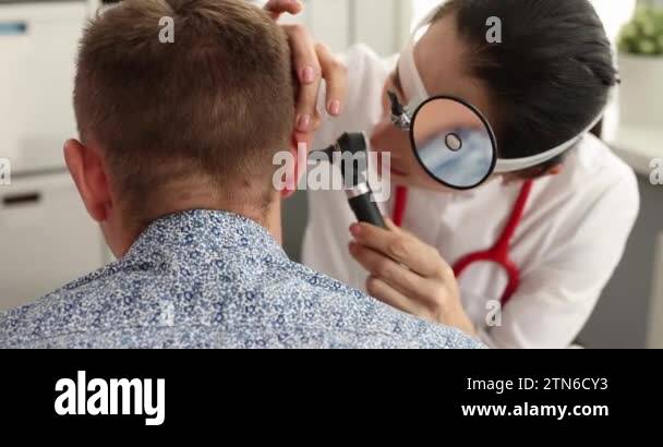 Otorhinolaryngologist with frontal reflector on forehead examining ...