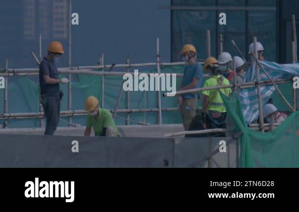 Builders On The Roof Of A High-Rise Building Under Construction In Hong ...