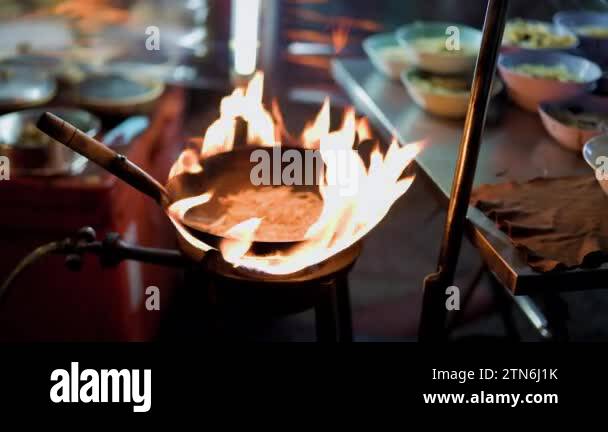 Wok pan cooking Asian food with fire flames and lit pasta and ...