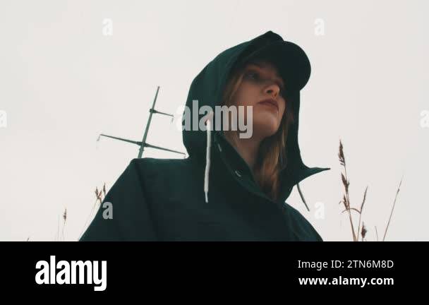 Young sleepy caucasian blonde girl in black cap and hood in front of ...