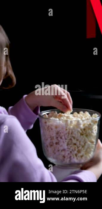 teenage sits on floor watches netflix on big screen of TV screensaver ...