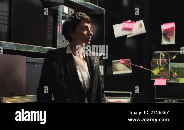 Woman inspector planning detective work, analyzing classified evidence ...