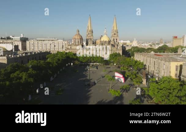 Beautiful blue sky above square with gothic spires towering city. Green ...