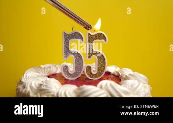 A candle in the form of the number 55 is lit, which is stuck into the ...