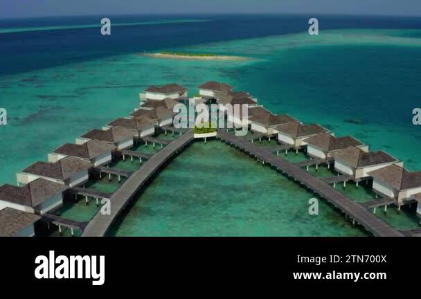 Aerial view of luxury villas over water on blue lagoon, white sandy ...