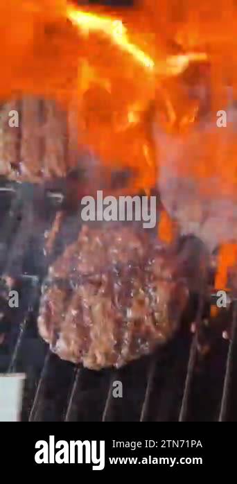 steak bbq burger patties fry over an open fire on the grate flip flame ...