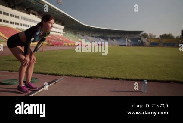 Side view handheld shot of young exhausted female athlete leaning ...