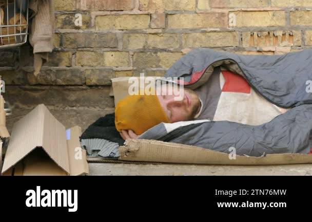 4K. Homeless man with carriage sleep near wall . Dolly shoot close up ...
