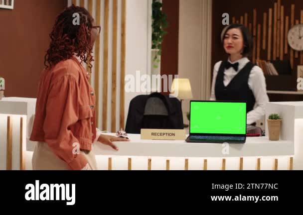 Tourist ringing concierge bell next to chroma key green screen mock up ...