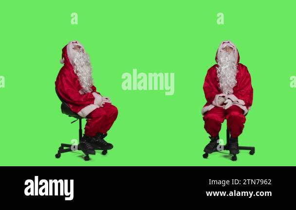 Santa claus embodiment poses on chair, sitting and looking around while ...
