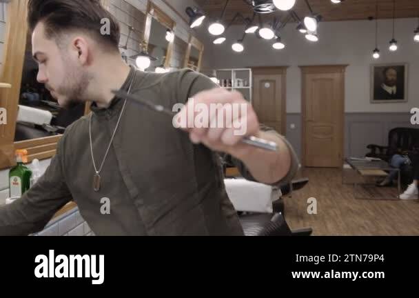 Hairdresser heating the blade of old-fashioned straight razor under ...