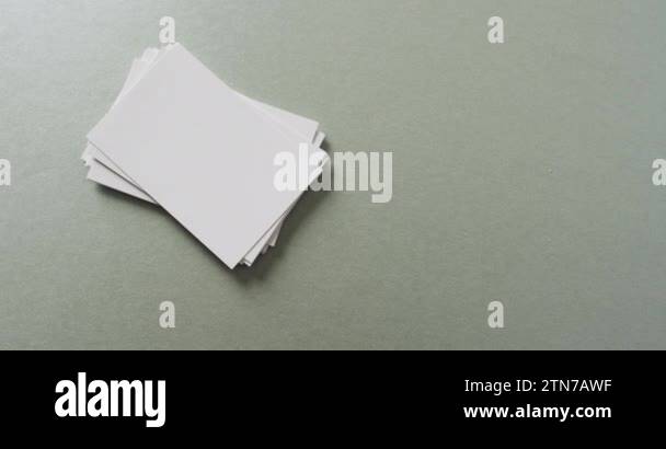 Overhead view of stack of blank white business cards on grey background ...
