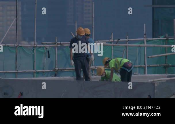 Builders On The Roof Of A High-Rise Building Under Construction In Hong ...