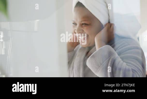 Happy african american plus size woman wearing towel on head in ...