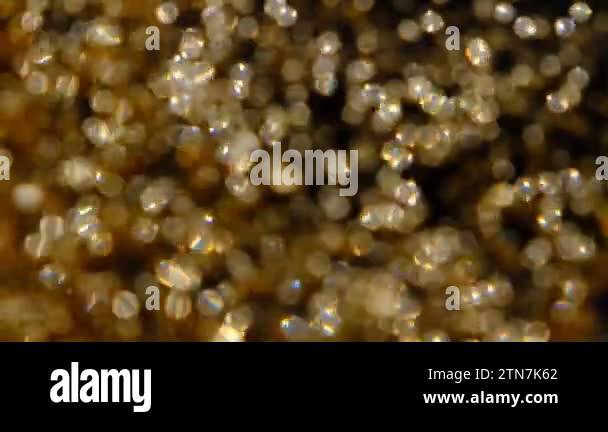 Golden glitter background. Beautiful transition with real gold particles. flying in wind on ...