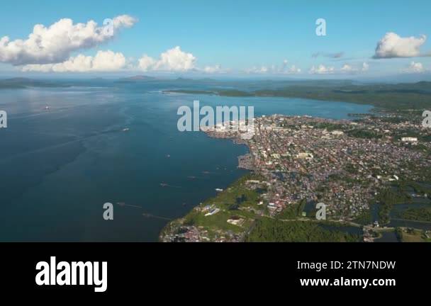 Aerial view of Surigao City with buildings and houses. Blue sea bay and ...