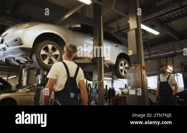 Two car mechanic father and son diagnosing vehicle at the auto service ...