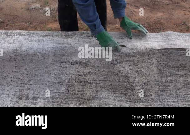 Cutting hole for an anchor in ruberoid for waterproofing foundation ...
