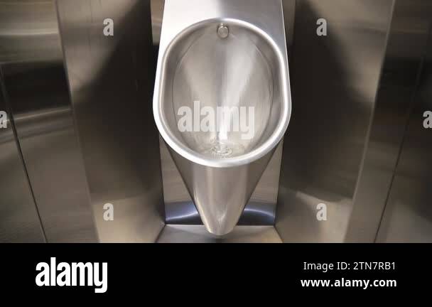 Sanitary metal urinal, toilet bowl in public bathroom with hygienic ...