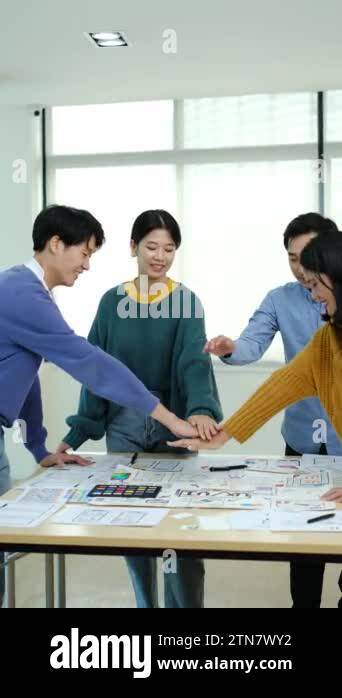 Vertical shot of start up business team stacking hands together in ...