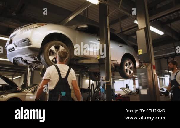 Automotive breakdown. Experts at work shop, standing in safety uniform ...