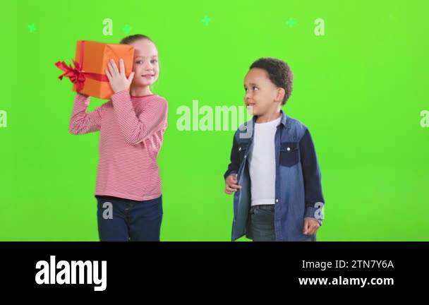 Preteen caucasian girl shaking present box, while african american boy ...