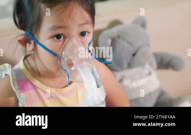 Kid girl making makes inhalation nebulizer steam sick cough at home ...