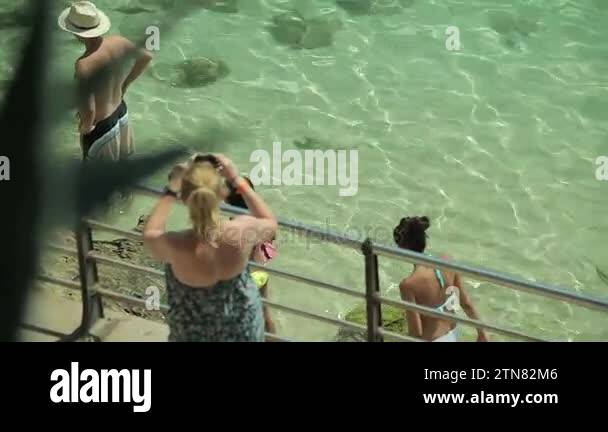 People bathe and rest on the city beach. Girls in a bikini goes along the seashore in a ...
