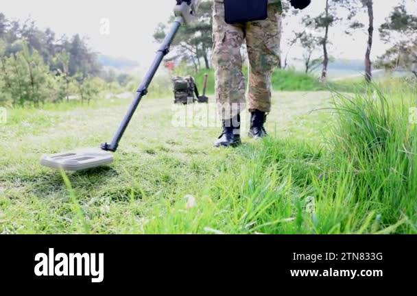 A man in a military uniform and bulletproof vest works in the forest ...