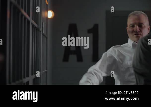 Prison officer leads criminal to jail cell, opens and locks it with ...