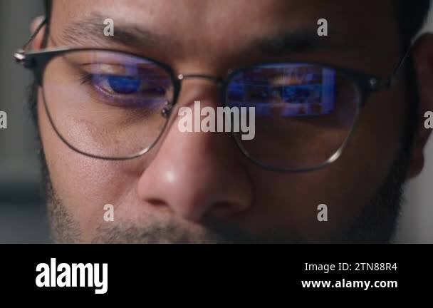 Close up male eyes in eyeglasses laptop monitor light programming ...