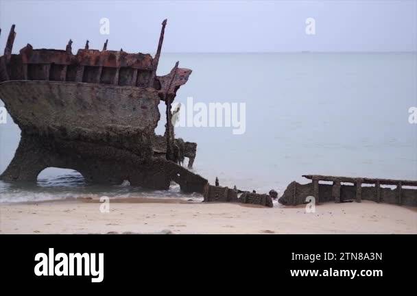 A Shipwreck Stranded On The Beach, With Small Waves In The Afternoon ...