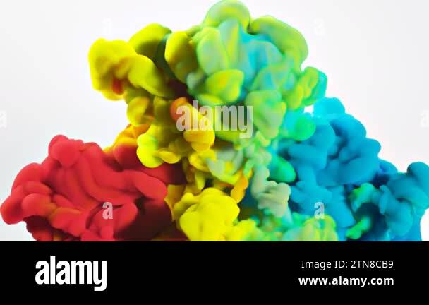 Colorful rainbow paint drops from above mixing in water. Ink swirling ...