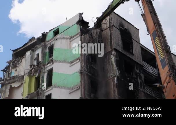 Excavator with hydraulic crusher at the demolition of a residential ...