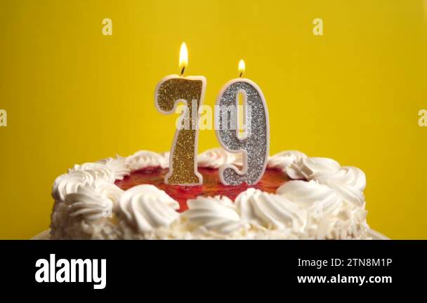 A candle in the form of the number 79, stuck in a holiday cake, is ...