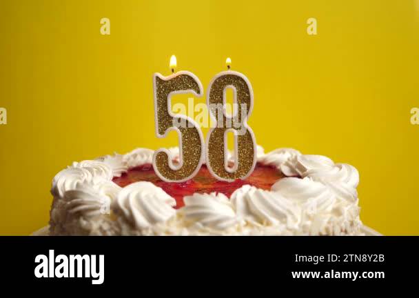 They blow out a candle in the form of the number 58, which is stuck ...