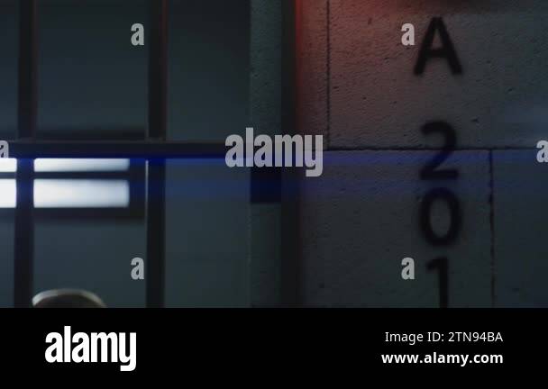 Number of jail cell on the wall. Elderly criminal in orange uniform ...