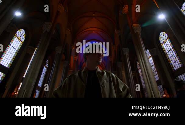 Stylish young attractive man in church rolls up his sleeves. An old ...