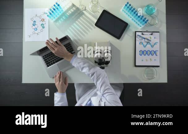 Scientist opening computer and setting up microscope in laboratory, top ...
