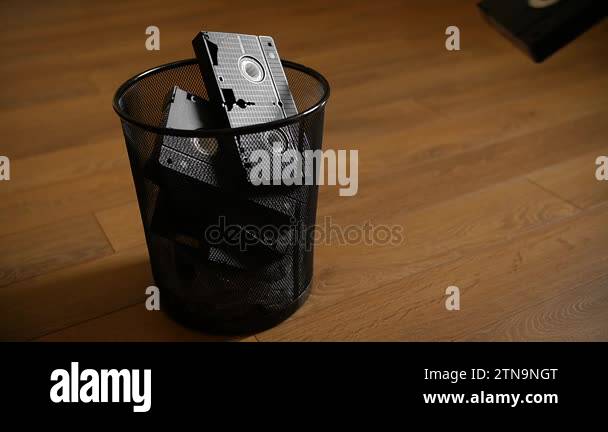 Stack of VHS video tapes dispose of in the trash over wooden background ...