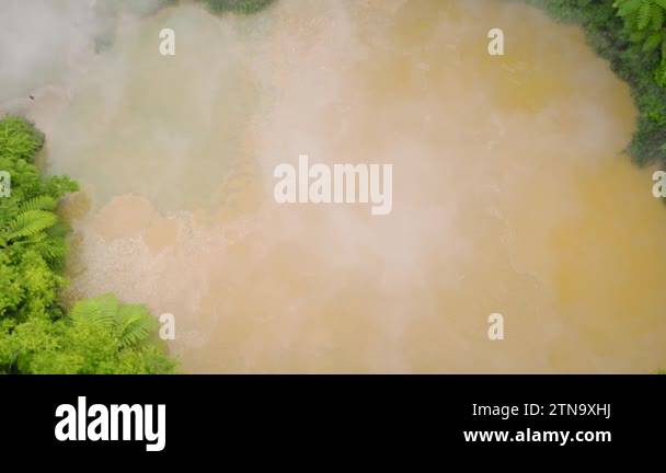 Boiling mud lake surrounded with mountain range. Natural beauty of Lake ...