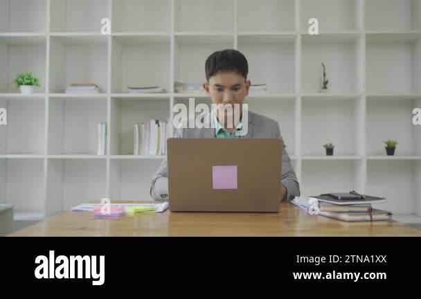 Asian business man Sitting working on laptop with office syndrome ...