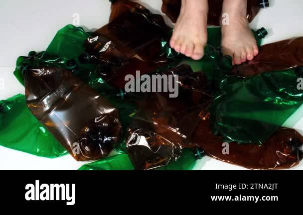Feet trample on a lot of plastic bottles for disposal. The concept of ...
