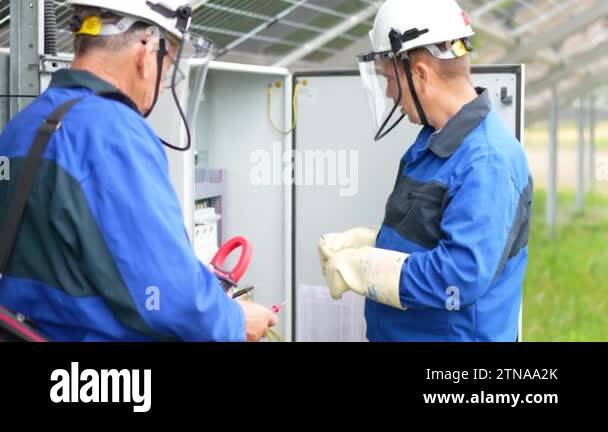 Two Service Engineers or electrician working on checking transformer site and solving problem ...